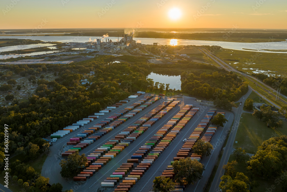 Large cargo container yard with many freight containers and big factory ...