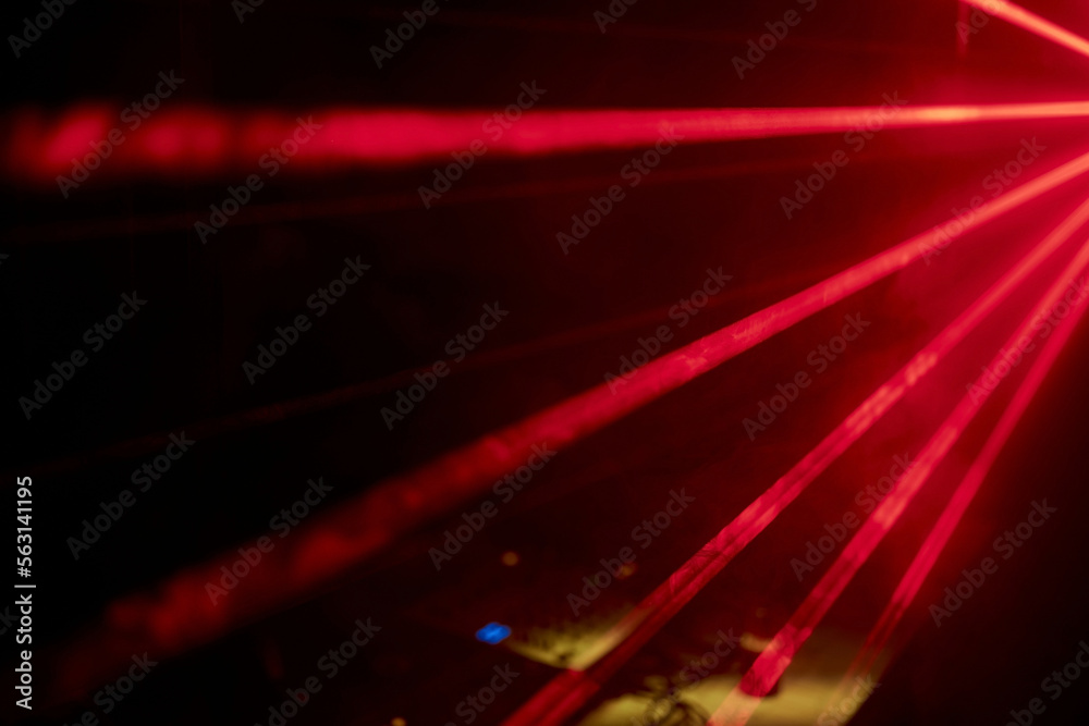 Bright red neon laser lights illuminate the darkness creating lines and ...