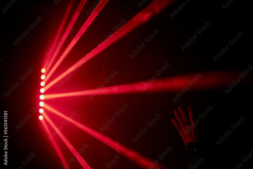 Bright red neon laser lights illuminate the darkness creating lines and ...