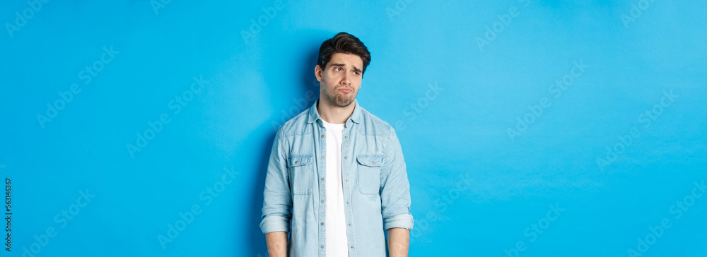Image of reluctant and sad guy in casual outfit looking left, frowning ...