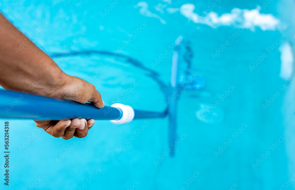 People cleaning swimming pool with suction hose. Close-up of man ...
