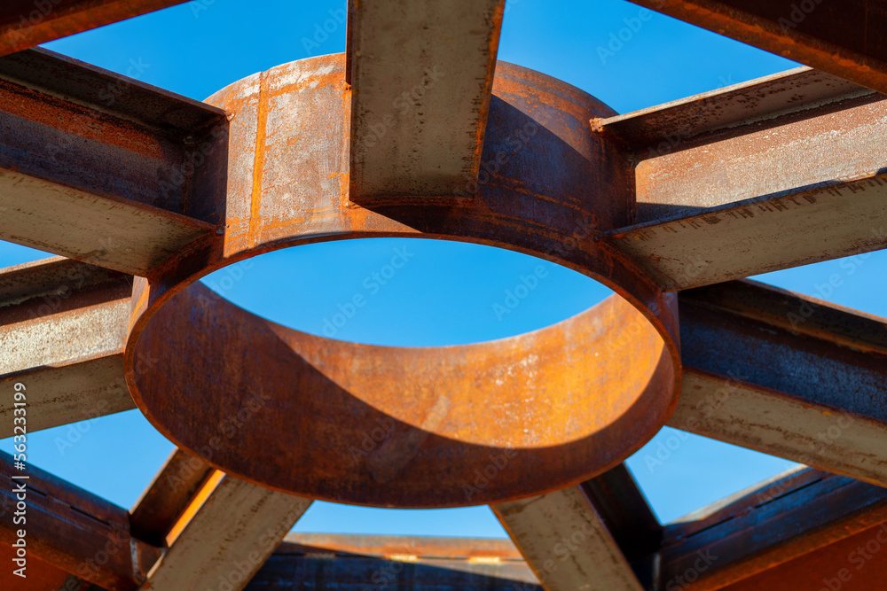 Round metal opening in gazebo or roofed area with rusted metal beams or ...