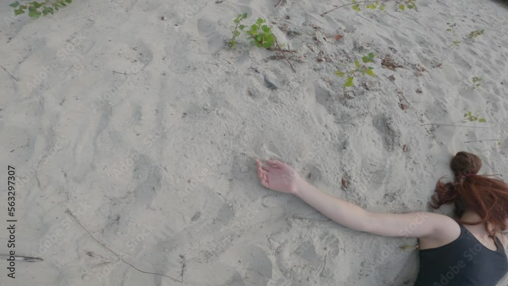 Dead body of a young woman lying on a sand of waistland. Killed ...