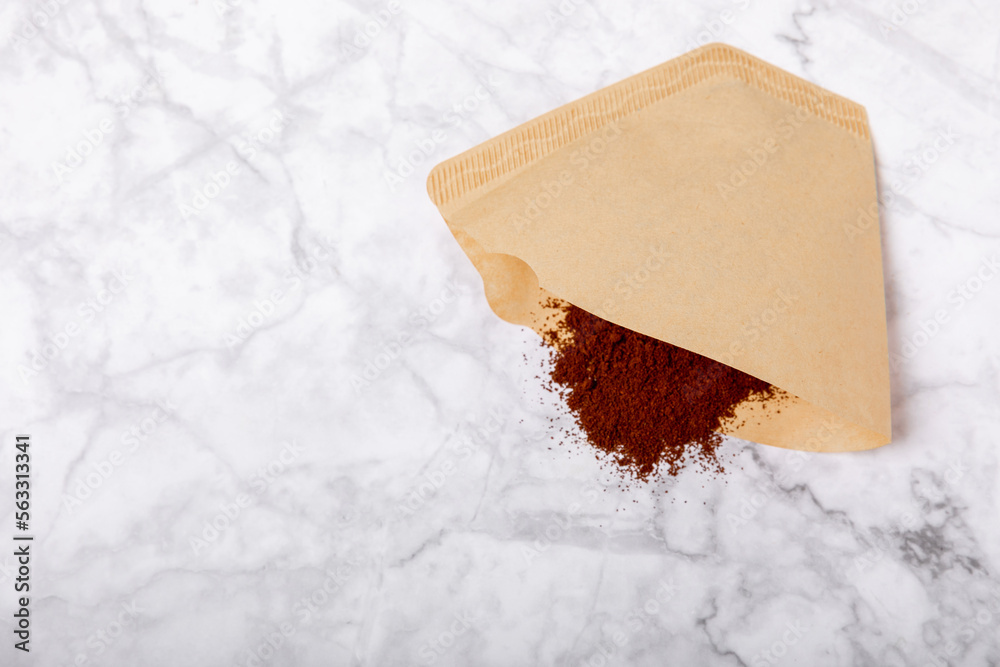 Coffee filter with ground powder on a white marble background. fragrant ...