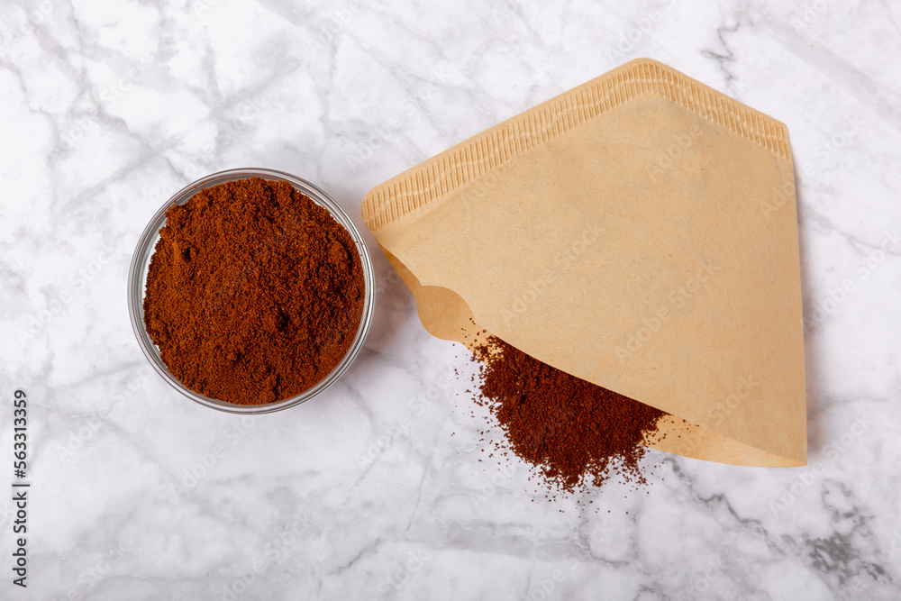 Coffee filter with ground powder on a white marble background. fragrant ...