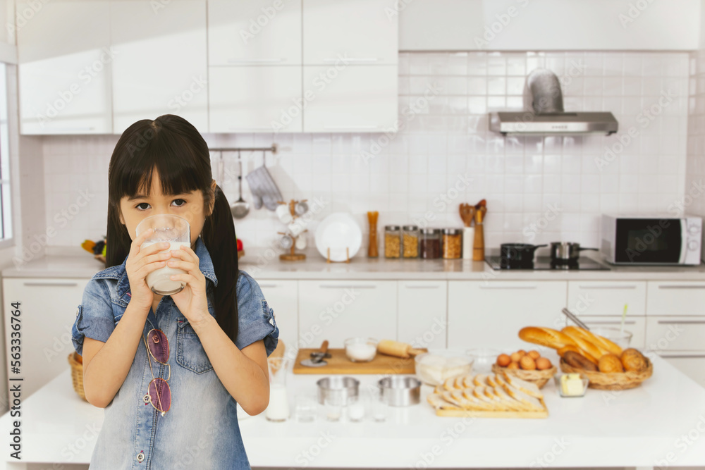 Cute Asian woman holding glass of fresh milk standing drinking milk in ...