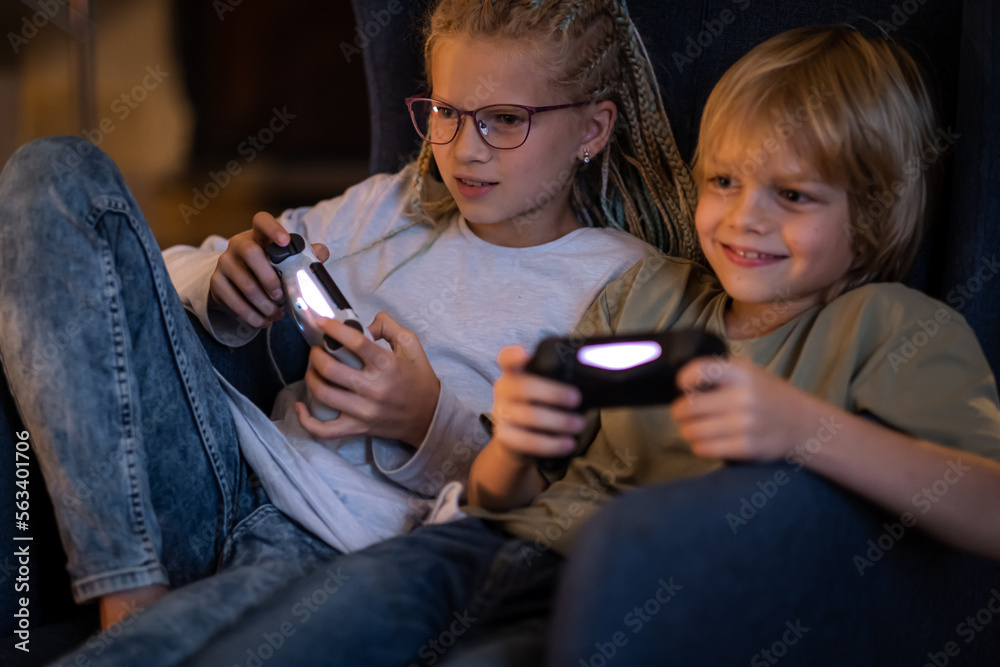 boy and girl playing video game console using joystick or controller ...