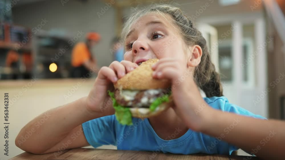 child kid eating a burger in a cafe. fast food nutrition health concept ...