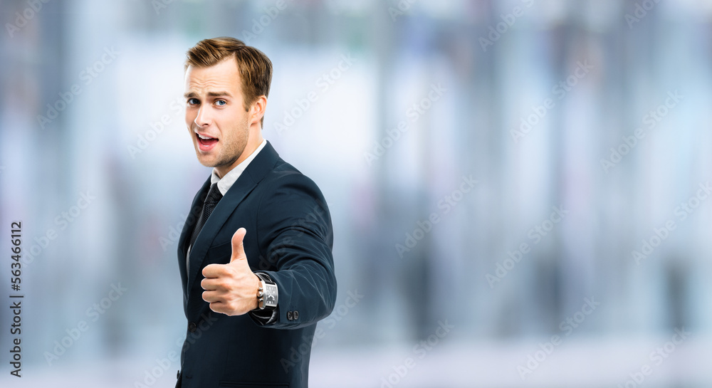 Excited businessman in black suit showing thumbs up like hand sign ...