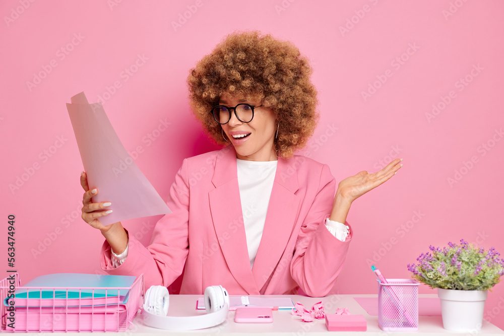 Foto Stock Horizontal shot of angry woman worker with curly hair holds ...