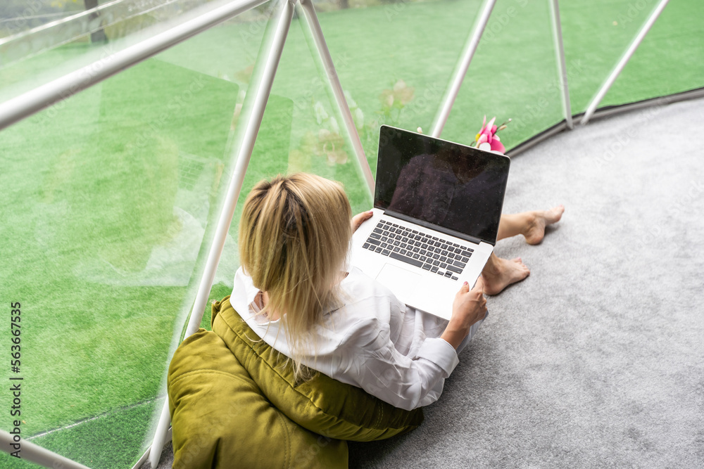 Young caucasian woman using and watching on laptop computer on in dome ...