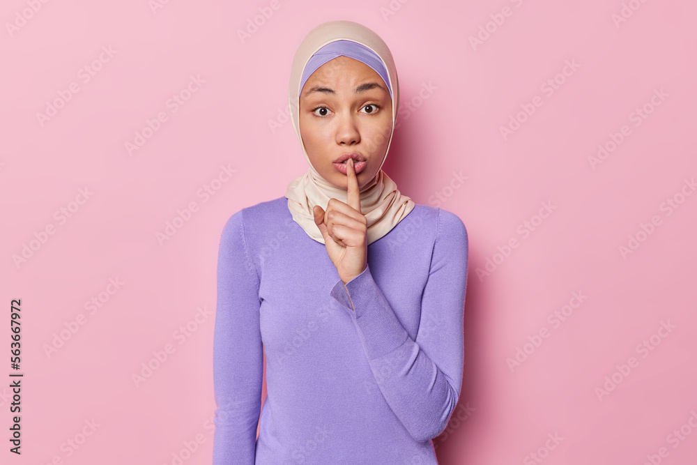 Mysterious young Muslim woman presses index finger to lips shares ...