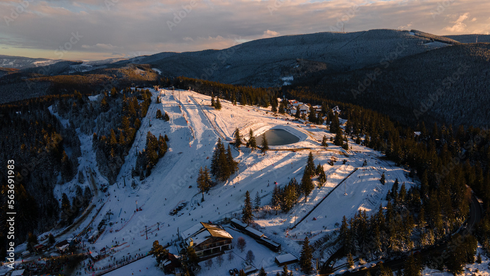 Aerial view of a skying slope on top of the mountain in winter season ...
