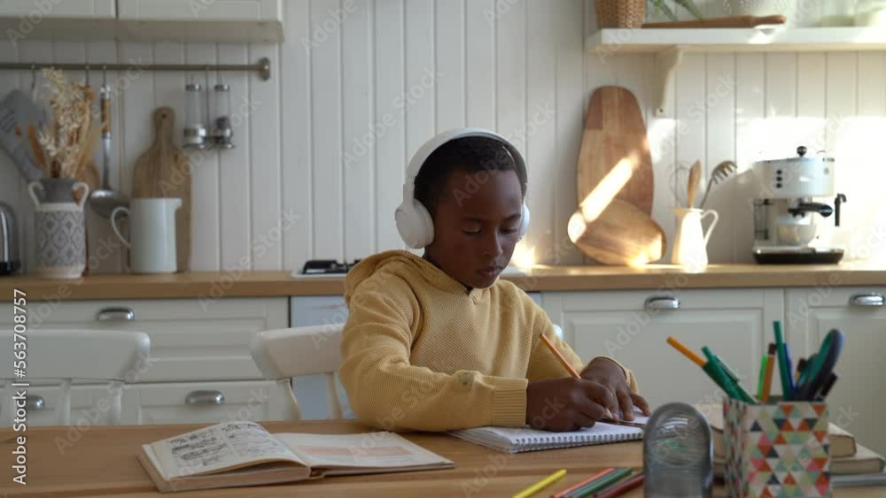 Focused kid African American boy sitting at desk working on engineering ...