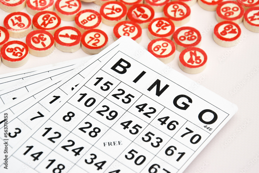 Many wooden chips with numbers and cards for a board game of bingo or ...