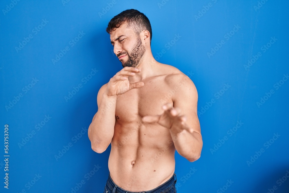 Handsome hispanic man standing shirtless disgusted expression ...
