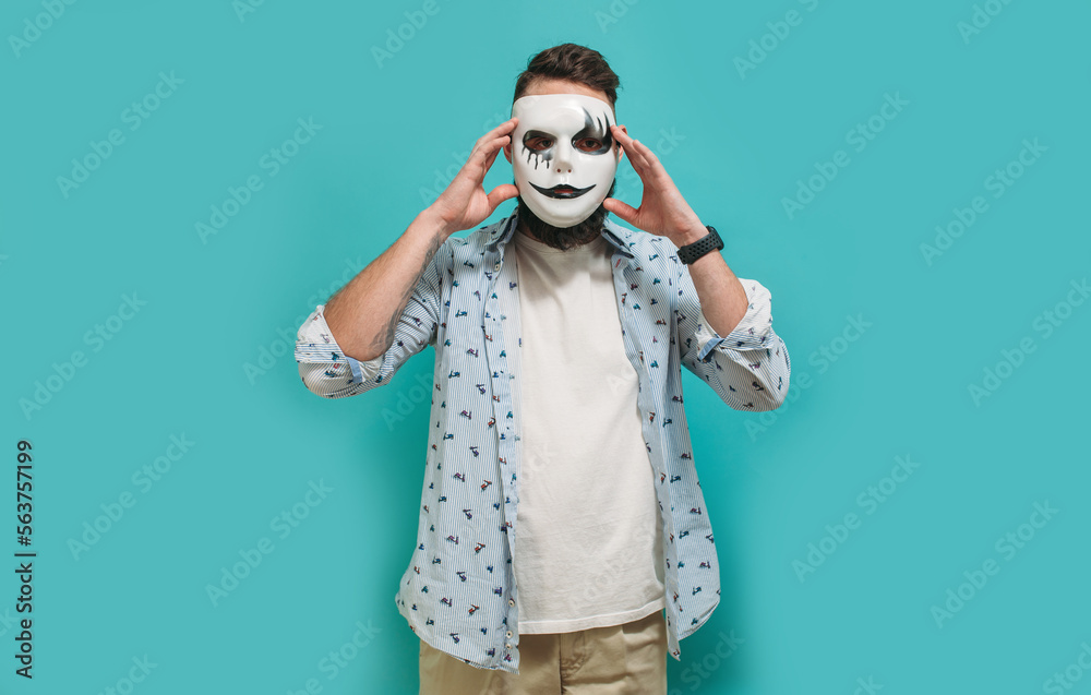 Portrait of a man with a beard covering his face with a white mask ...