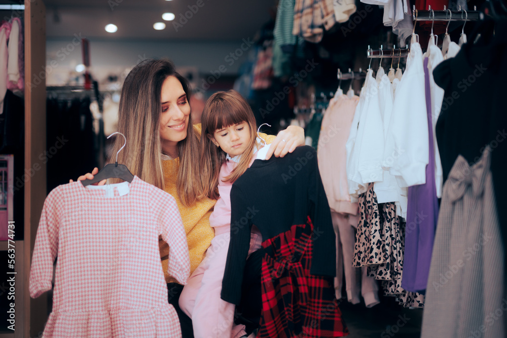Mother and Toddler Daughter Choosing a Dress in Fashion Store. cheerful ...