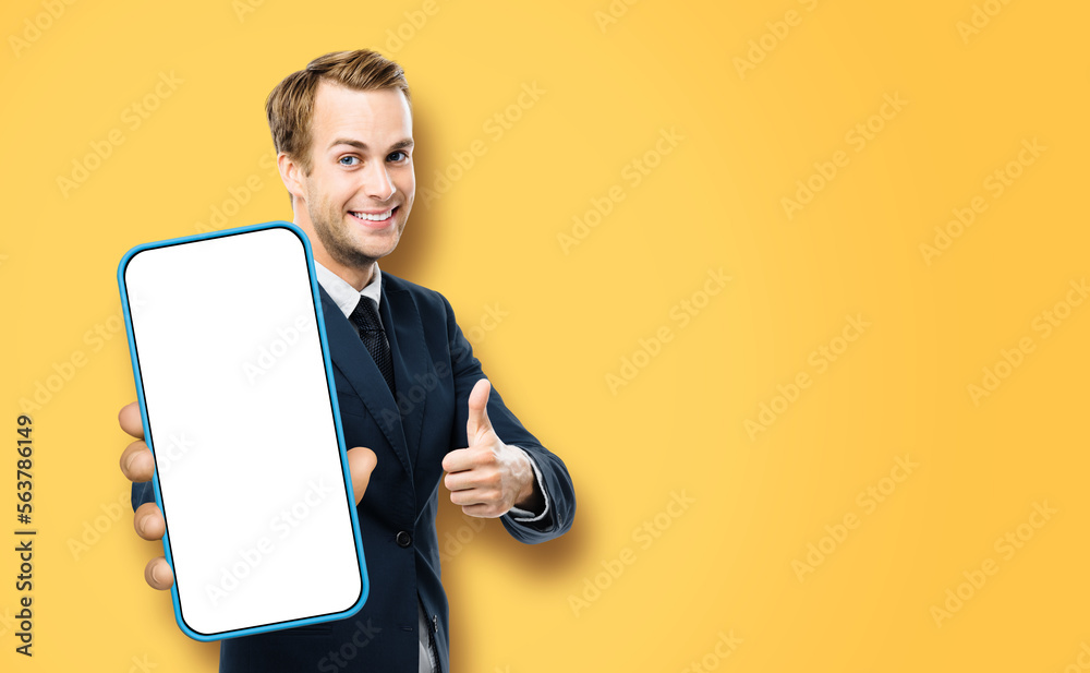 Excited smiling business man in black suit, showing cell phone, mobile ...