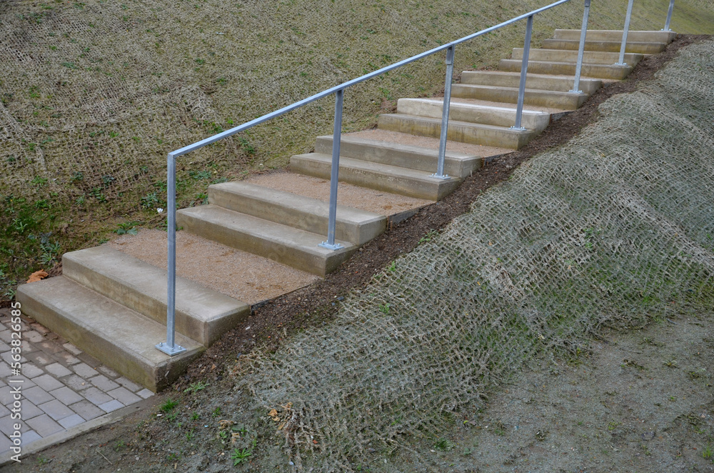 outdoor park stairs on a slope. jute mat protects against erosion. seed ...