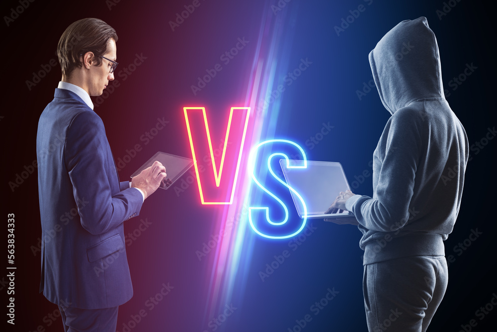 Hacker with laptop versus businessman with tablet on blurry dark neon ...