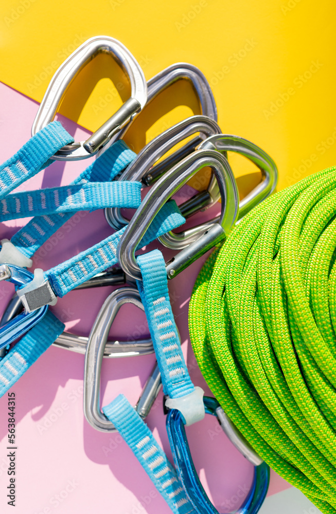 green rope and climbing and mountaineering equipment lies on a colored ...