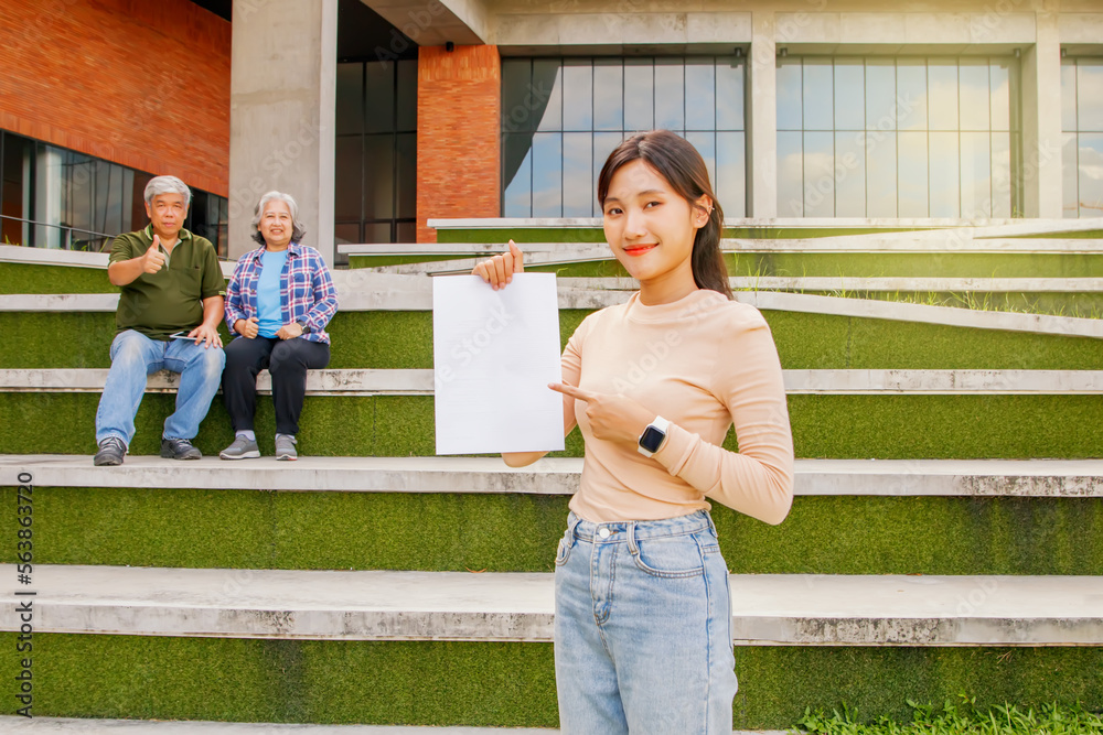 Happy daughter stand presents graduation certificate to parents waiting ...
