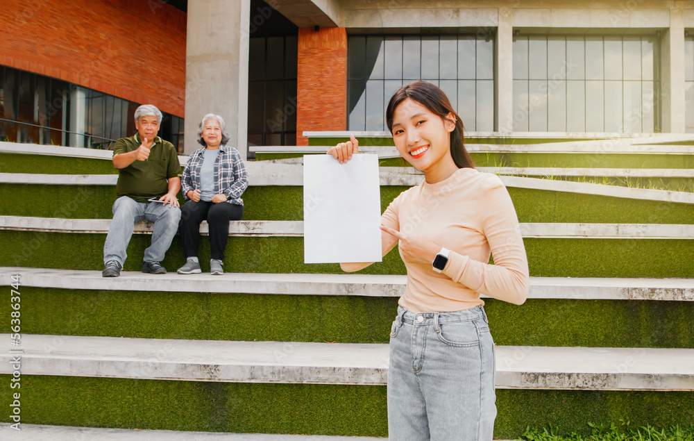 Happy daughter presents graduation certificate to parents waiting in ...