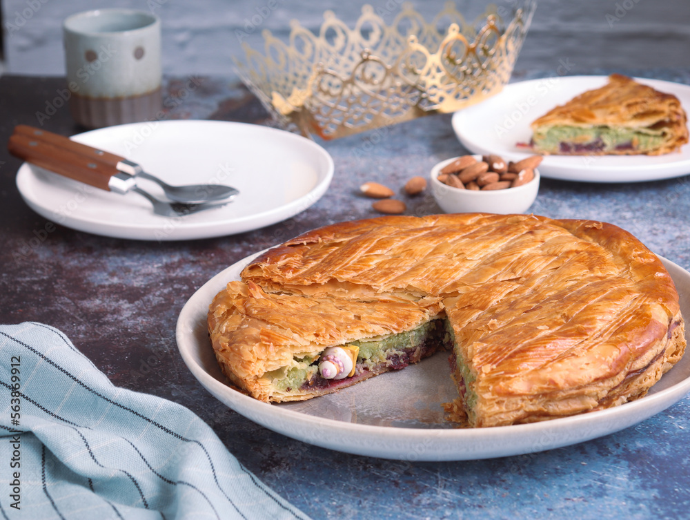 A pieces of traditional French galette des rois or King cake, with fève ...