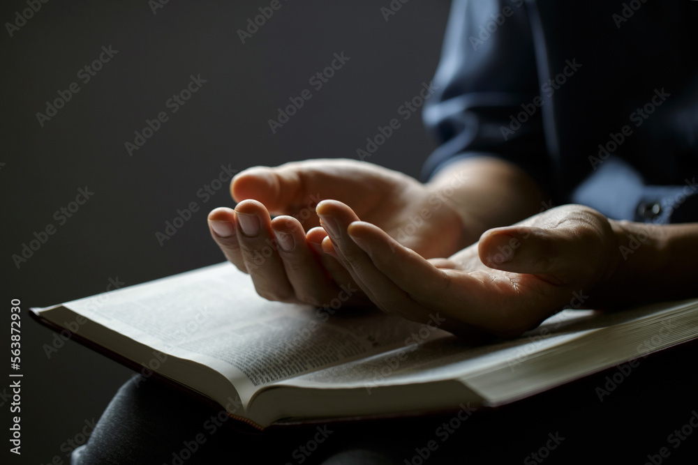 Praying hands, Man prays with hands together over a Holy Bible, In the ...