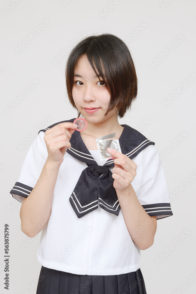 コンドームを持つ女子学生 Stock 写真 | Adobe Stock