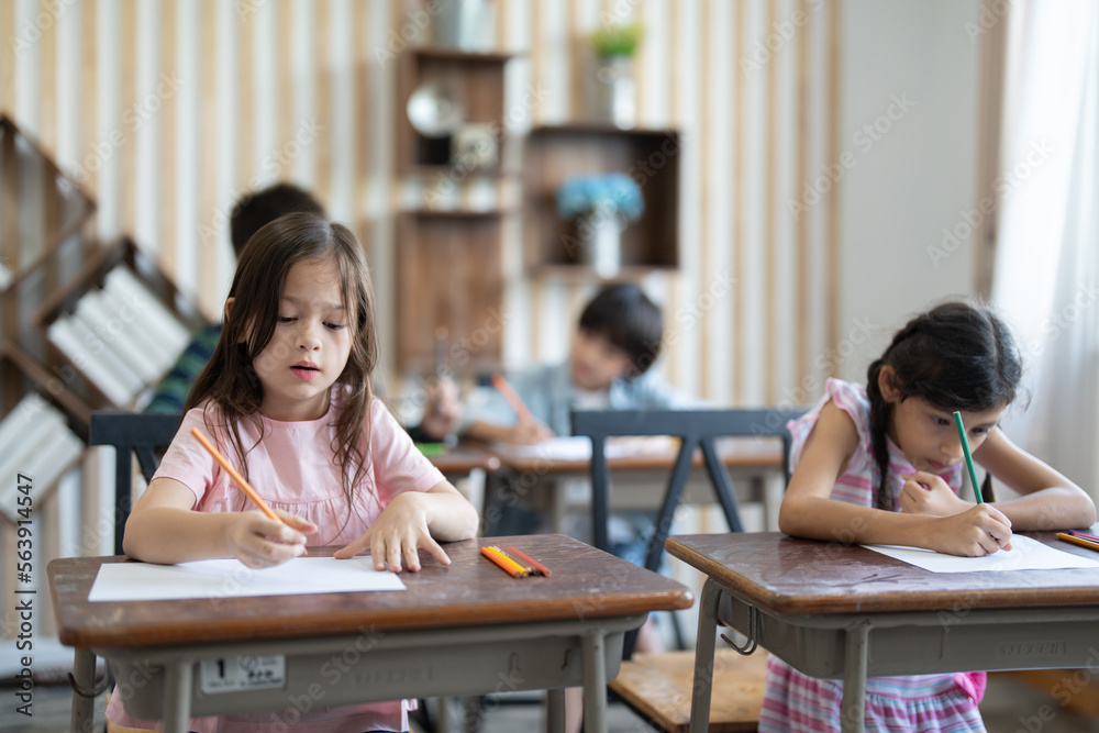 Cute little girl using color pencil drawing on paper in art study class ...