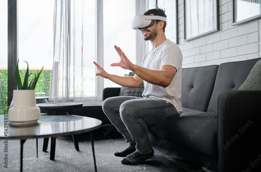 Virtual reality, futuristic technology and man on sofa with headset for ...