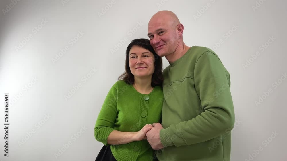 adult man and woman stand on white background in green sweaters husband ...