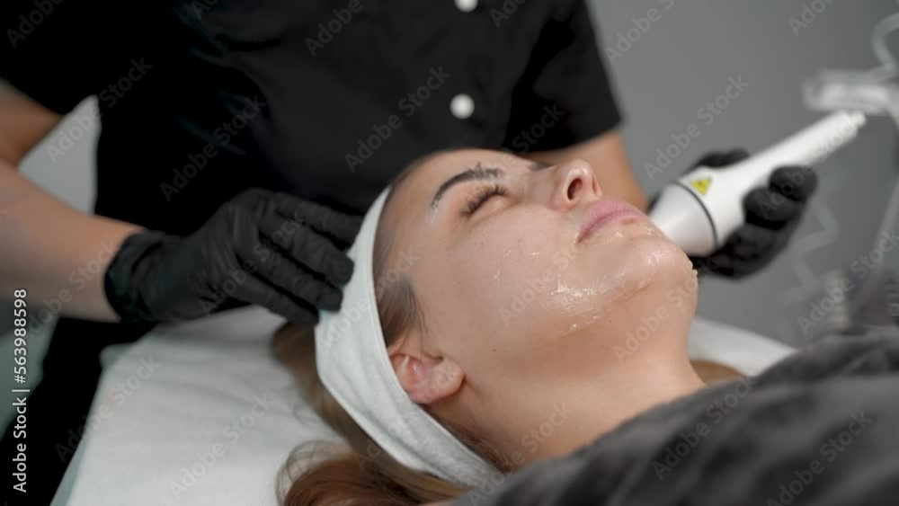 RF lifting procedure. A woman applies the rf lifting procedure on the ...
