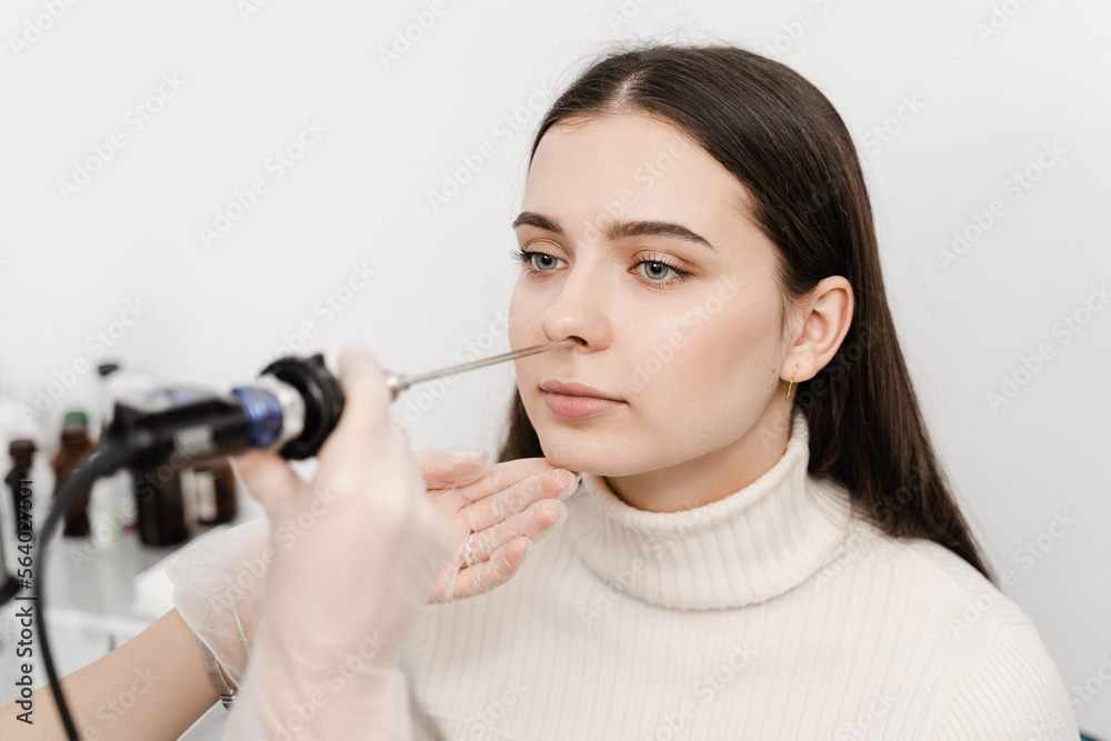 ENT doctor otolaryngologist with headlight treat nose woman patient ...