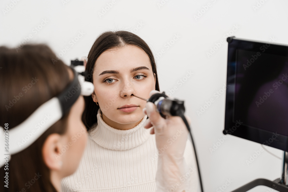 ENT doctor otolaryngologist with headlight treat nose woman patient ...