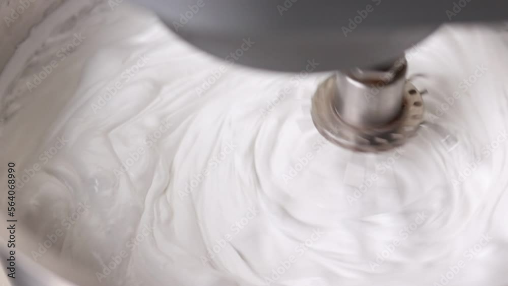 Kitchen mixer is beating the eggs white egg whites into a thick white ...