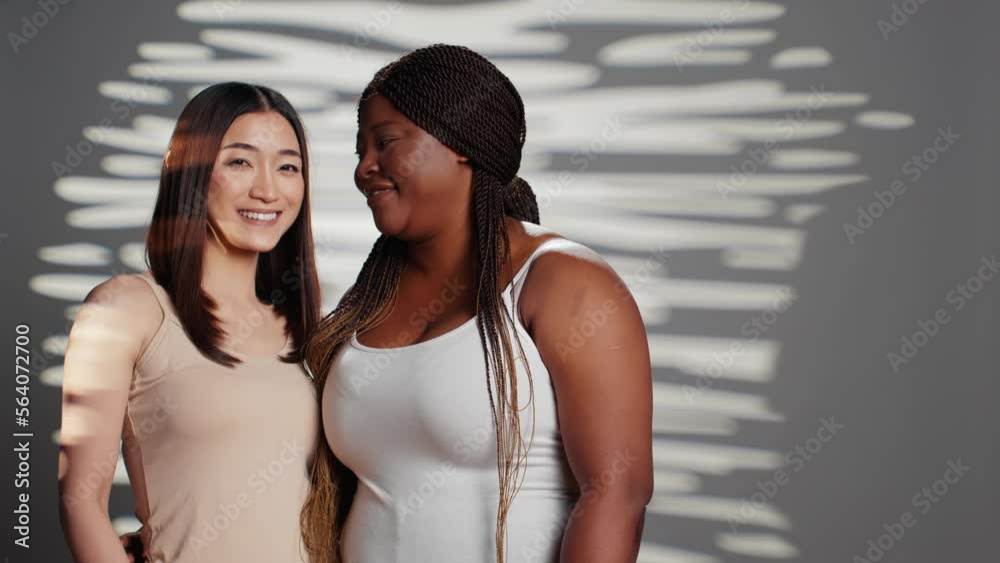 Happy diverse ladies hugging and posing in studio, promoting wellness ...