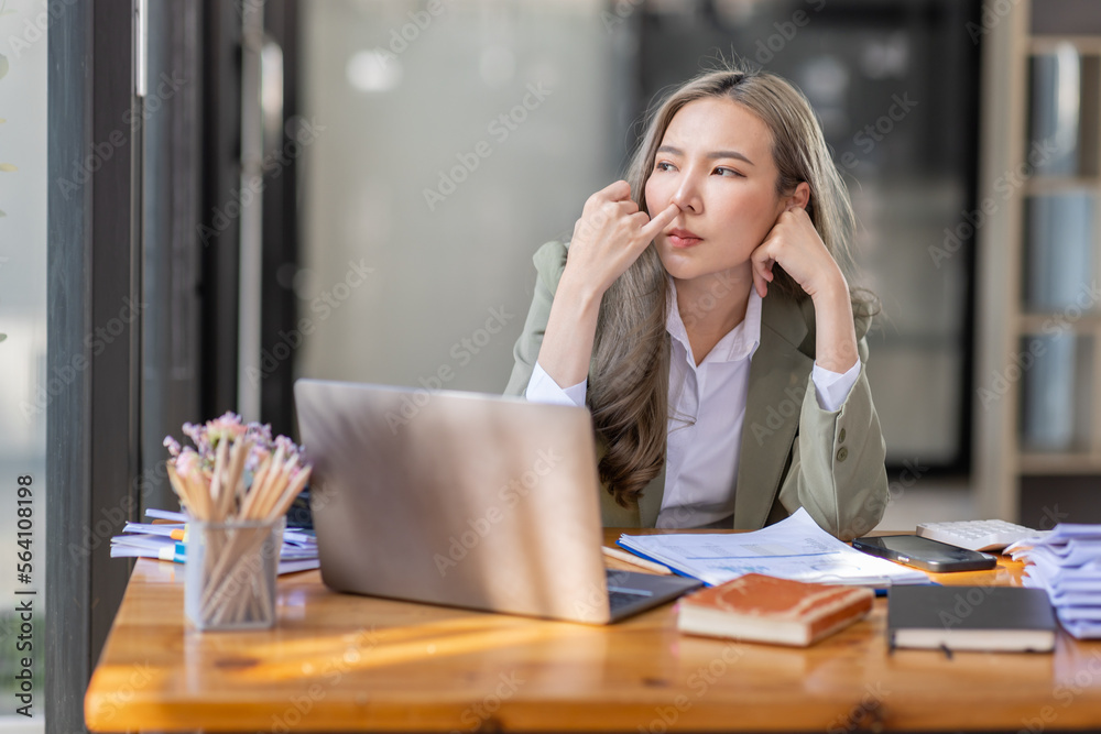 Foto de Bored Young business Asian woman sitting at her workplace at ...