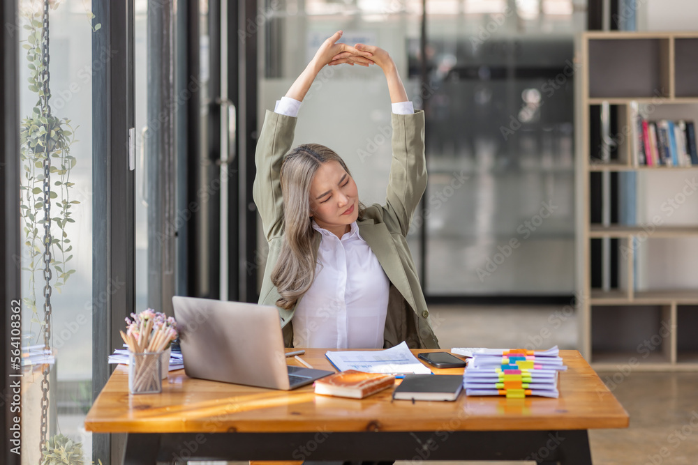 Foto de Bored Young business Asian woman sitting at her workplace at ...