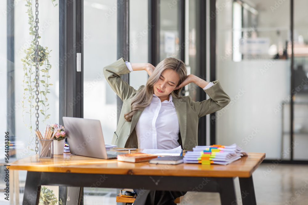Foto de Bored Young business Asian woman sitting at her workplace at ...