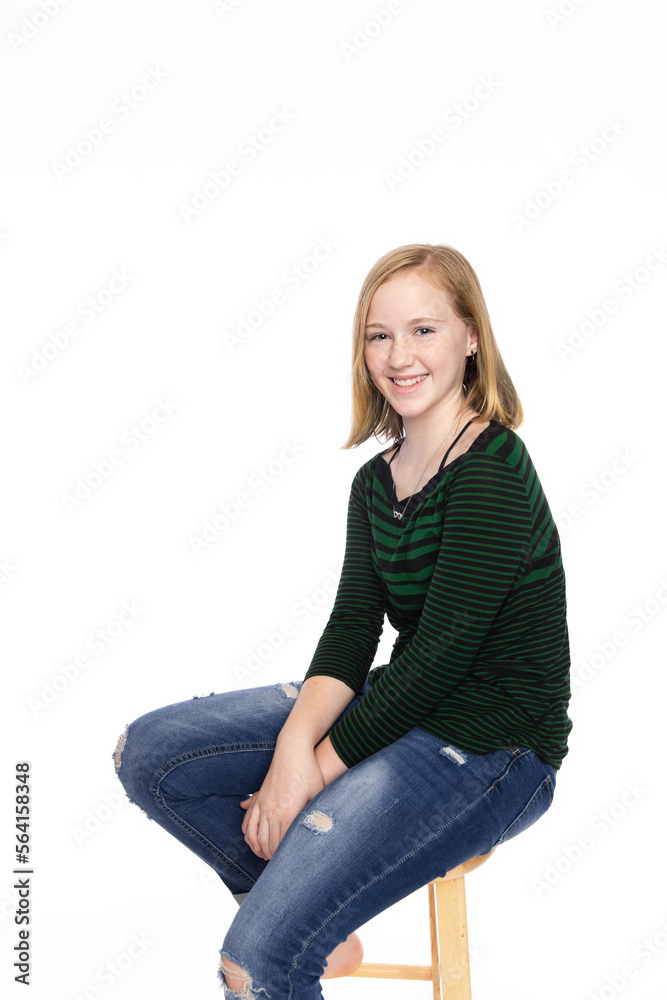 Preteen tween girl with blond hair and freckles sitting comfortably on ...