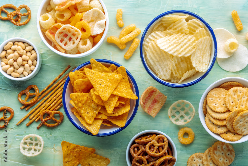 Salty snacks. Party food on a blue background. Potato and tortilla ...