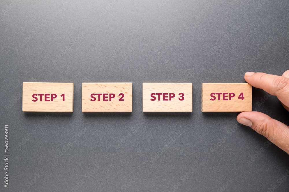 Closeup hand arrange the wood blocks of Step 1 to Step 4 on gray ...