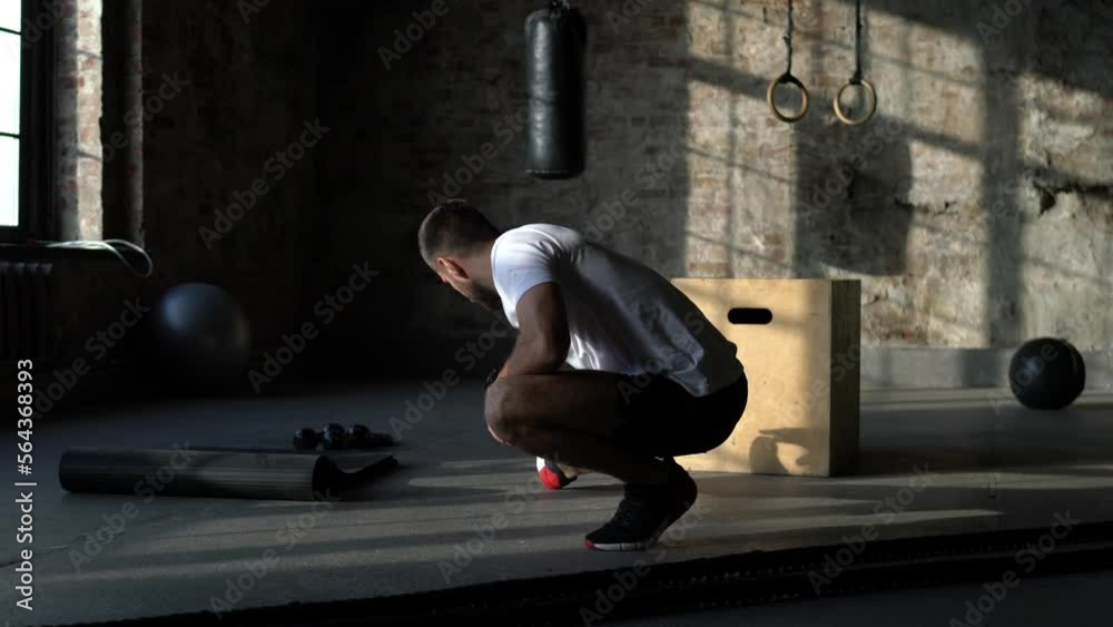 Caucasian bodybuilder stretching legs muscles before intensive workout ...