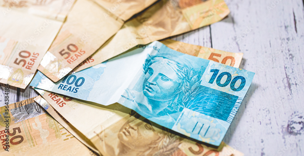 Notas do Real Brasileiro sobre uma mesa de madeira. Economia brasileira ...