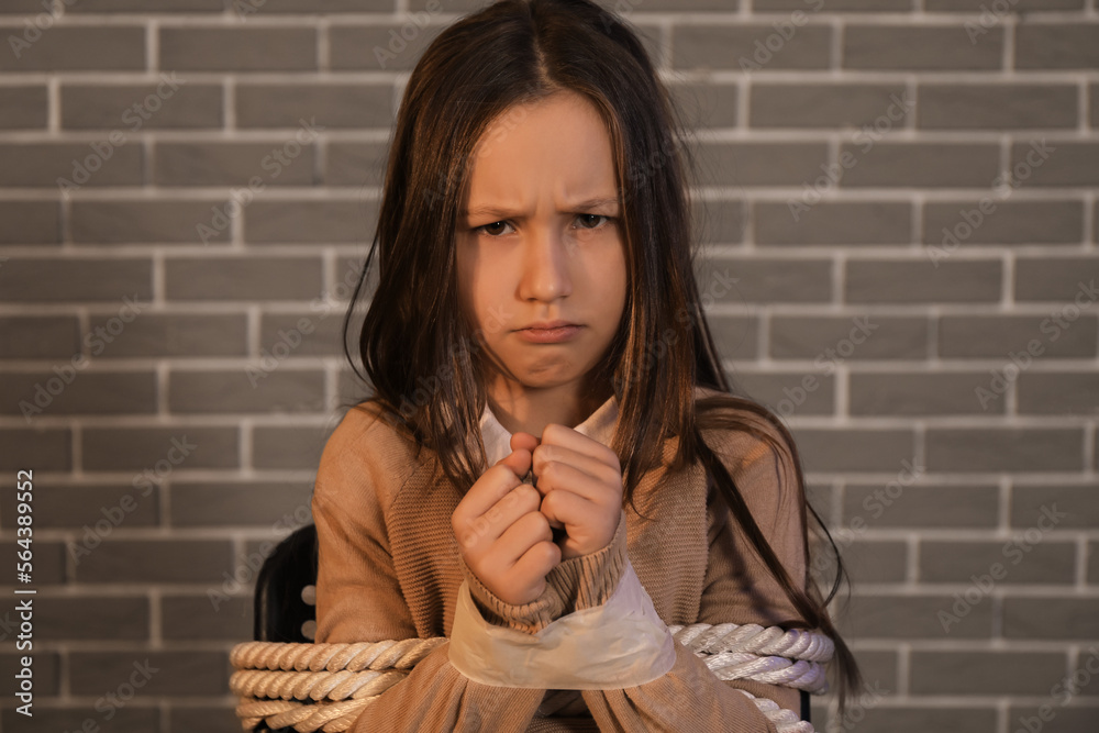 Scared little hostage tied to chair on brick background Stock Photo ...