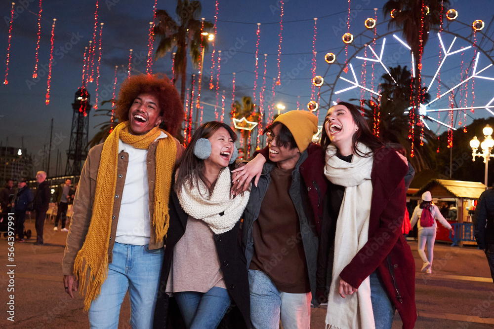Colleagues walking around the amusement park at night with their arms ...