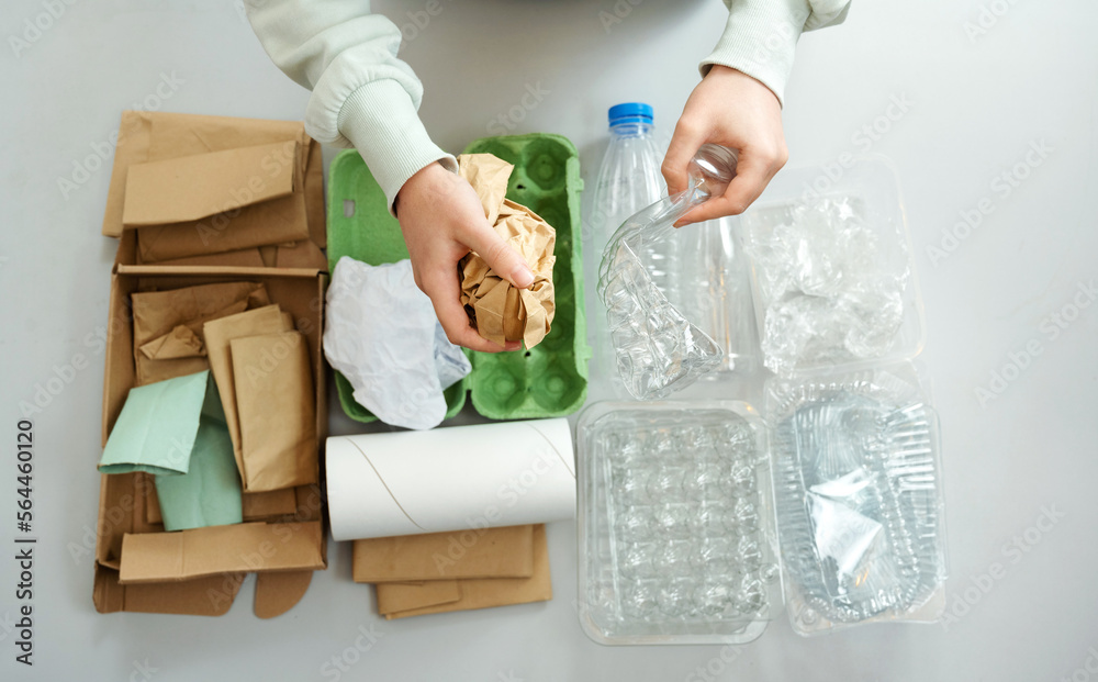 Garbage separation concept. Female hands separate paper and plastic ...